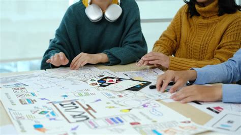 Developer Team Collaborating And Planning Template Layout For Mobile Application In Office Stock