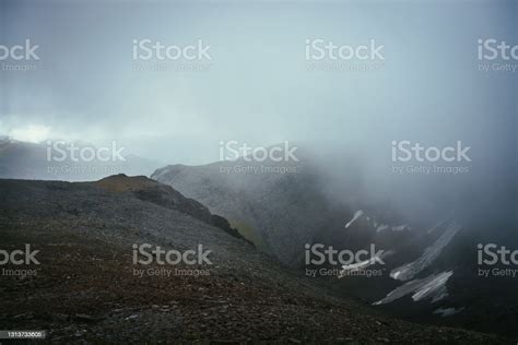 고원지대의 한정지대에 있는 어두운 분위기의 풍경 낮은 구름 사이 위험한 산과 아비 구름에 위험 산 패스와 날카로운 바위 산에서 위험한 흐린 비오는 날씨 0명에 대한 스톡