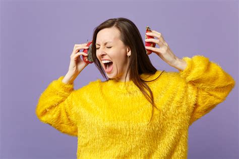 모피 스웨터에 비명 소녀는 눈을 폐쇄 유지 보라색 파스텔 배경에 고립 된 귀 근처 피타 야 용 과일의 Halfs를 개최 합니다 사람들은 생생한 라이프 스타일 휴식 휴가