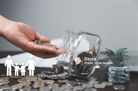 사업가는 돼지 저금통과 종이 가족을 손에 들고 기부 저축 자선 가족 재정 계획 개념 기금 마련 연금 금융 위기 개념을 보호하는 위치를 차지합니다 가계에 대한 스톡 사진 및