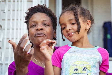 Young Girl Sitting And Eating Ice Cream With Her Mother Del