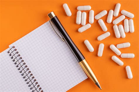 의료 캡슐과 오렌지 배경에 펜 빈 노트북 주위에 알 약 닫습니다 0명에 대한 스톡 사진 및 기타 이미지 0명 개념 건강 진단 Istock