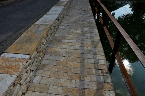 수영장 연못 소방대 옆에서 돌 클래딩이 있는 돌벽 벽에 포함된 금속 자전거 랙과 쓰레기통 녹슨 코텐 강철 난간 베이지 색 라임 포장 0명에 대한 스톡 사진 및 기타 이미지