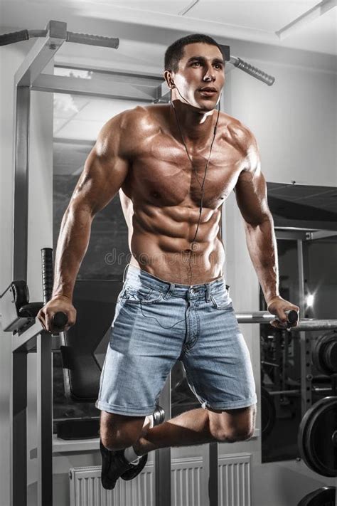 Muscular Man Working Out In Gym Doing Exercises On Parallel Bars
