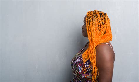 회색 그런 지 벽 쪽을 보고 오렌지 머리 띠를 입고 동안 젊은 아프리카계 미국인 여자 긴장 자신감 미소와 자연 스러운 얼굴