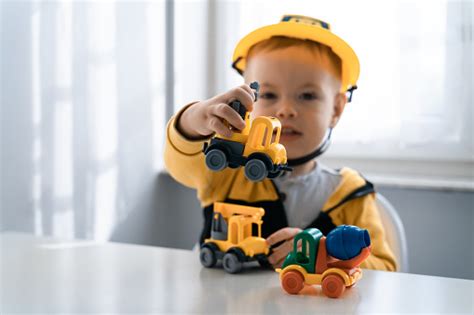 아이들은 집에서 건설 기계를 가지고 놀고 엔지니어가되는 꿈을 꾼다 작은 건축업자 교육 상상력 목적성 개념 굴착기를 가진 소년 2 3 살에 대한 스톡 사진 및 기타 이미지