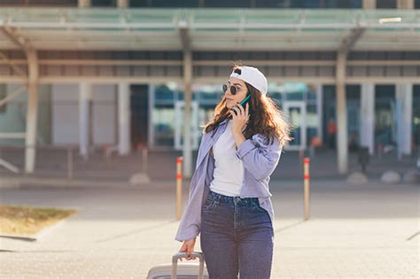 여행 가방과 전화를 가진 젊은 아름다운 소녀 여자 누군가를 호출 택시를 호출 찾고 공항에서 비행기로 도착 낯선 도시에 25 29