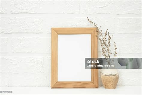 나무 테이블에 프레임 모형 마른 잔디와 현대 세라믹 꽃병 중립 색상 사진 프레임 질감이있는 흰색 벽 배경에 포스터 템플릿 스칸디나비아 인테리어 공간을 복사합니다 액자에 대한