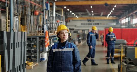 안전모를 쓴 진지한 자신감 넘치는 젊은 여성 공장 감독이 압축기 공장 공장을 따라 걷고 직원들의 작업을 통제하고 있다 사진 Unsplash의 안전모 이미지