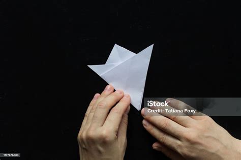 눈송이 만들기 7단계 검은 배경에 접힌 1 3 부분으로 종이 삼각형을 접는 여성 손 만들기에 대한 스톡 사진 및 기타 이미지 만들기 삼각형 손 Istock