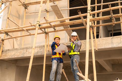 토목 엔지니어는 관리 팀과 의사 소통하기 위해 워키 토키로 작업을 검사합니다 엔지니어는 건설 현장 주택 건축 아이디어의 감독자에게 주택 건설을 권장합니다 건설 산업에 대한