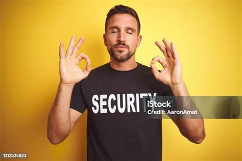 노란색 고립 된 배경에 보안 유니폼을 입고 젊은 보호 남자는 손가락으로 명상 제스처를하고 눈을 감고 미소 요가 개념입니다 감시에 대한 스톡 사진 및 기타 이미지 Istock