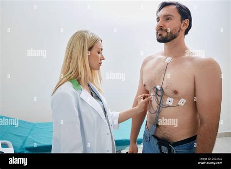 Man Using Holter With Ecg Sensors To Monitor His Heart Health Under Supervision Of Licensed