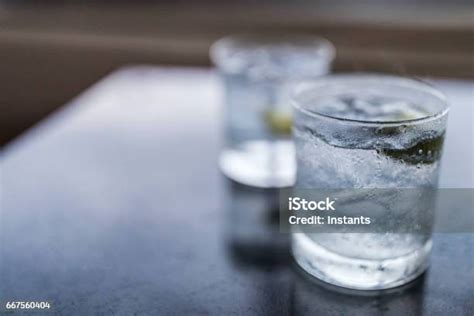 밖에 서 총을 가까이 찬 진 각 하나에 석 회 쐐기와 얼음 조각으로 토 닉 2 잔의 0명에 대한 스톡 사진 및 기타 이미지