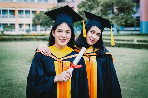 졸업식에서 대학 학위 증서를 받은 후 젊은 아시아 여성 대학 졸업생들이 친구들과 함께 즐거운 축하를 합니다 축하합니다 졸업식