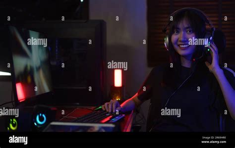 Female Cyber Hacker Gamer In Headphone Playing Games Or Hacking
