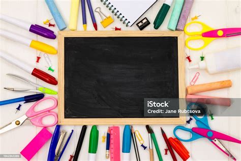 흰색 나무 배경에 학교 검은 분필 보드로 돌아 색상 공급 맨 위 보기입니다 복사 공간을 참조하십시오 교육 개념 배낭에 대한 스톡