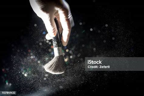 빛과 연기와 어두운 배경에 화장품 파우더와 함께 손에 메이크업 브러쉬 파우더 스플래시 온 다크 개념에 대한 스톡 사진 및 기타 이미지 Istock