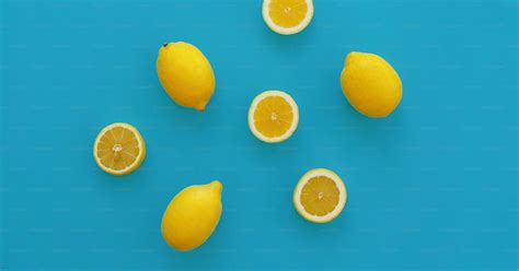 밝은 파란색 종이에 노란색 레몬과 레몬 조각 트렌디 한 플랫 레이 과일 현대 이미지 상위 뷰입니다 육즙이 많은 여름 비타민과 다이어트 개념 팝 아트 스타일 창조적