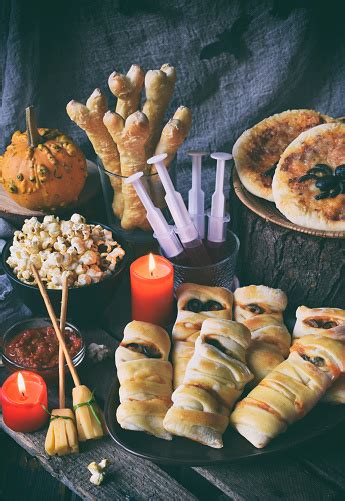 할로윈 트릭이 나 치료 자 재미 있는 맛 있는 음식 및 나무 배경미니 피자 빵 스틱 치즈 올리브 케첩 팝콘 호박 주스 텍스트에 대 한 공간을 복사 합니다 10월에 대한 스톡