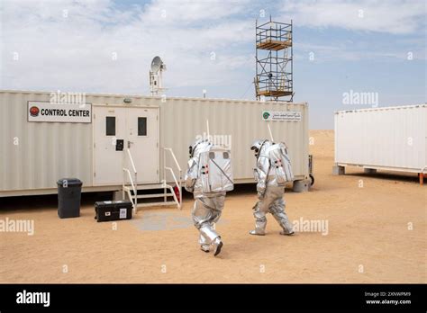 Analog Astronauts In Silver Spacesuits Walking Near A Control Center During A Mars Simulation