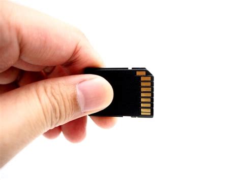Premium Photo Cropped Hand Holding Memory Card Against Black Background
