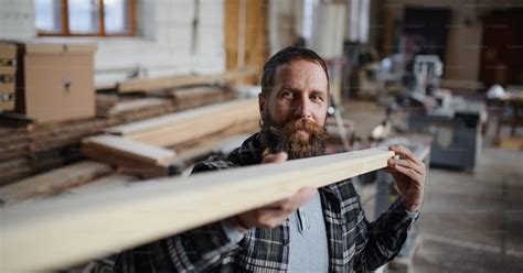 목수 작업장에서 실내에서 나무 판을 들고 다니는 성숙한 남성 목수 중소 기업 개념입니다 사진 Unsplash의 목수 이미지