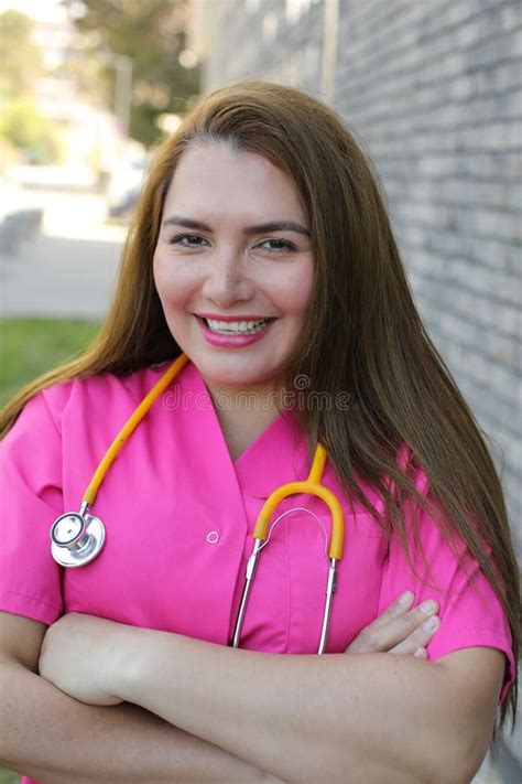 Health Worker Wearing Pink Scrubs And Yellow Stethoscope Stock Image