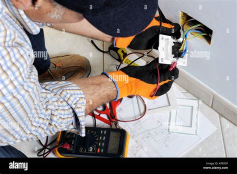 Electrician Measuring The Voltage On Switches And Sockets Of A Residential Electrical System