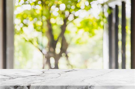 빈 흰색 대리석 석조 테이블 상단과 녹색 나무 외부 창 배경홈 인테리어에 흐릿한 거실 제품을 전시하거나 몽타주에 사용할 수 있습니다 대리석에 대한 스톡 사진 및 기타 이미지
