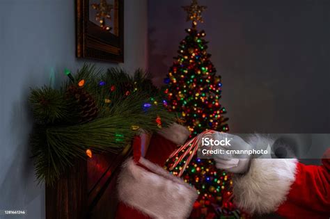 산타 클로스는 벽난로 맨틀에 매달려 스타킹에 3 사탕 지팡이를 배치 위치 선정에 대한 스톡 사진 및 기타 이미지 위치 선정 캔디 케인 크리스마스 Istock