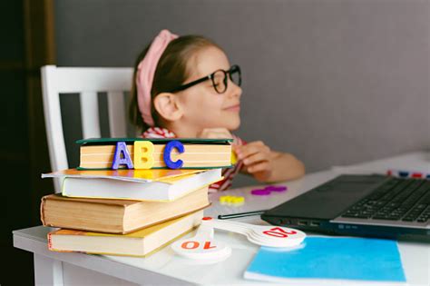 원격 학습 온라인 교육 집에서 디지털 태블릿 노트북 노트북을 가지고 공부하고 학교 숙제를하는 여학생 소녀 교과서가 있는 테이블에 앉아 있습니다 6 7 살에 대한 스톡 사진