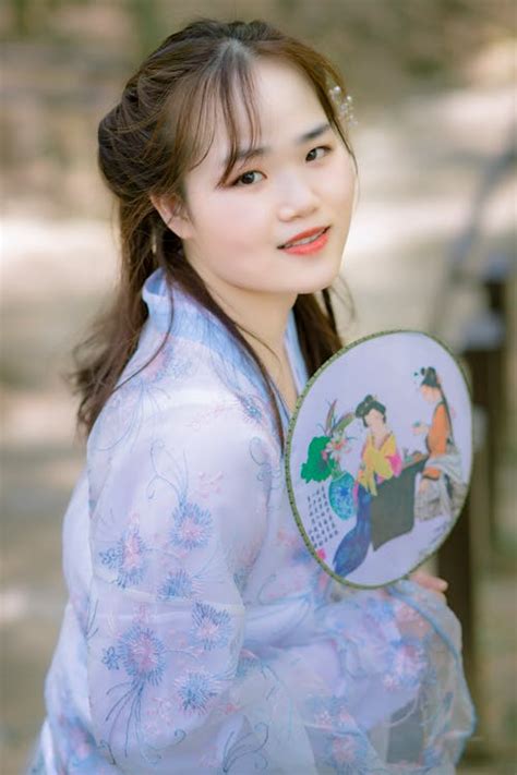 배경을 흐리게 사람 선풍기 수직 쐈어 여성 잡고 있는 전통 의상 한푸에 관한 무료 스톡 사진