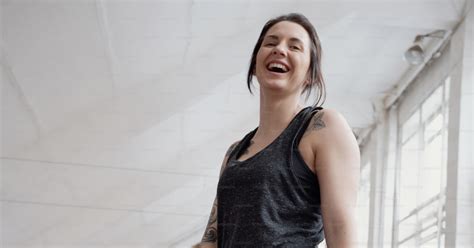 검은 운동복을 입은 젊은 운동 여성은 전투 로프를 들고 체육관에서 크로스 트레이닝 운동을 하는 동안 유쾌하게 웃고 있다 사진