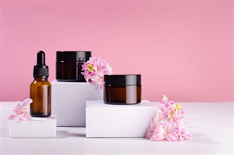 화장품 을위한 호박 색 유리 용기 크림 봄 꽃과 흰색 연단에 서 에센셜 오일 화장품 생산을 위한 브랜딩 아이덴티티를 위한 템플릿 가벼운에 대한 스톡 사진 및 기타 이미지