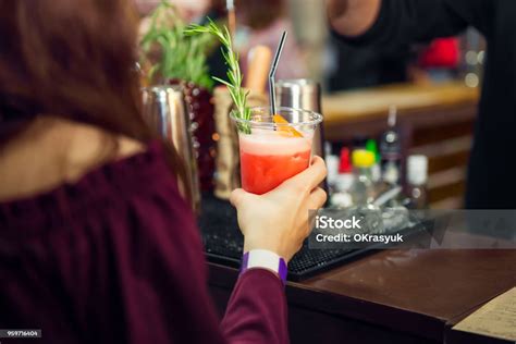 Backview 여자 손 배경에 플라스틱 막대기 카운터와 붉은 Coctail 유리를 들고 레저 및 라이프 스타일 마시는 칵테일 밤문화 및 파티 이벤트 개념 Sective
