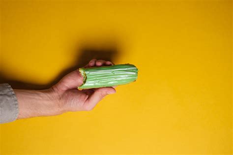 미니멀리즘 스타일의 음식 회색 또는 노란색 배경에 손에 맛있는 에클레어 사람 라이프 스타일 개념입니다 복사 공간 모의 노란색 배경에 대한 스톡 사진 및 기타 이미지 Istock