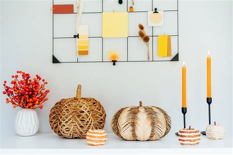 아늑한 가을 가정 인테리어 장식 다양한 장식용 고리 버들 세공 호박 양초 흰색 테이블에 꽃병에 계절 꽃 벽에 가을 색상 팔레트 노트가 있는 무드 보드 기분 영감 가을에 대한