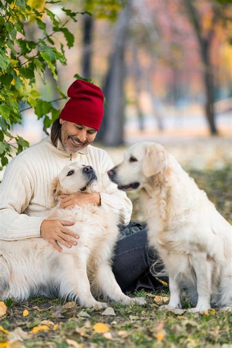 Vertical Photo Of A Middle Aged Man And Two Dogs Golden Retriever