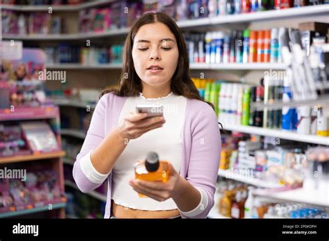 Female Shopper Scanning A QR Code Using A Mobile Phone In Cosmetics Store Stock Photo Alamy