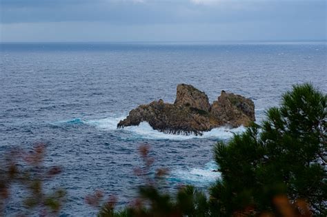 넓은 바다에 있는 외로운 작은 바위 섬 바다에서 폭풍우가 몰아치고 성난 파도가 작은 섬에 부딪히며 하얀 물보라를 일으키며 폭발합니다 폭풍우가 몰아치는 바다의 바위 0명에