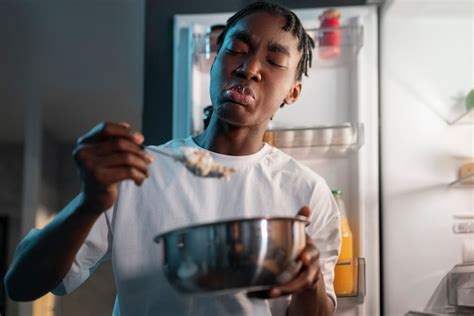 Junger Mann Der Mitten In Der Nacht Zu Hause Neben Dem K Hlschrank Einen Snack Isst