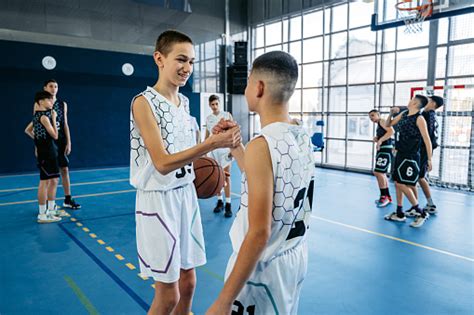 두 명의 십대 농구 선수가 실내 코트에서 경기를 마친 후 악수하고 있다 2명에 대한 스톡 사진 및 기타 이미지 2명 가볍게 두드리기 건강한 생활방식 Istock