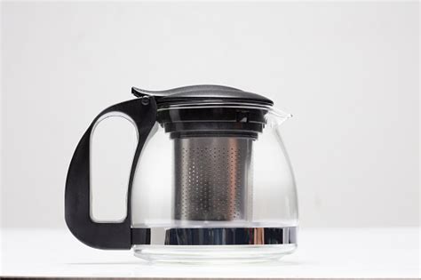 손잡이와 잎 필터가 있는 유리 찻주전자는 휴식을 위해 말린 잎 홍차에 뜨거운 물을 넣습니다 물에서 말린 잎 차를 걸러내는