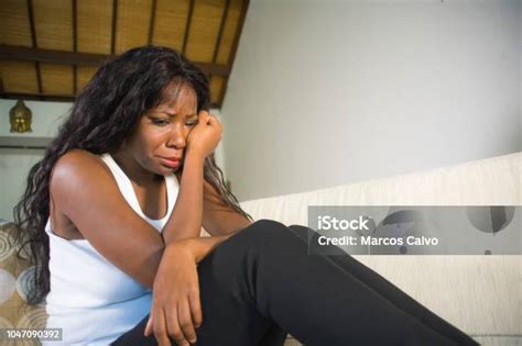 매력적이 고 검은 흑인 여 자가 앉아 소파 집에서 우울 하 고 슬픈 영 소파 불안과 좌절 우울증 문제 및 불안 위기 울고 절망 고통 느낌 30 39세에 대한 스톡 사진 및
