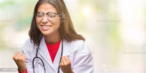 젊은 아랍 의사 여자 격리 된 배경에 매우 행복 하 고 흥분 무기와 우승자 제스처를 하 고 웃 고 성공을 위한 비명 축 하