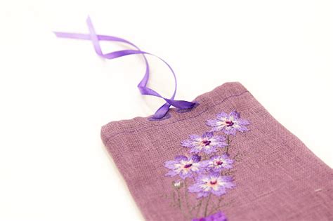 자수 꽃 보관 파우치가있는 보라색 린넨 파우치 말린 허브 향기로운 파우치 인테리어 세부 사항을위한 작은 품목을위한 파우치 흰색 배경 선택적 초점에 격리되어 있습니다