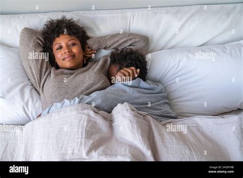 Son Sleeping With Mom On Bed At Home Stock Photo Alamy
