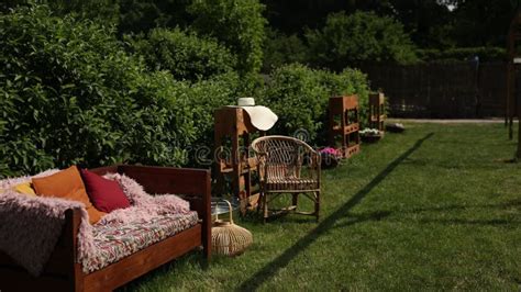 A Sofa And A Chair Stand On The Grass On The Terrace In The Garden Park