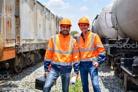 건설 과정을 점검하는 엔지니어 철도 열차 테스트 및 무선 통신으로 철도 역에서 철도 작업을 점검합니다 직장에서 안전복과 안전 헬멧을 착용한 엔지니어 2명에 대한 스톡 사진